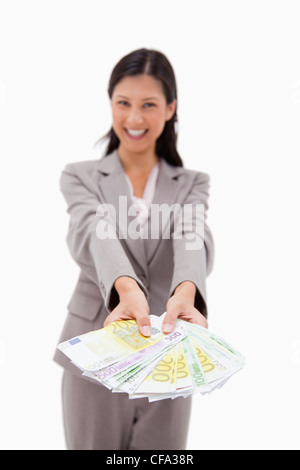 Money being offered by smiling businesswoman Stock Photo - Alamy