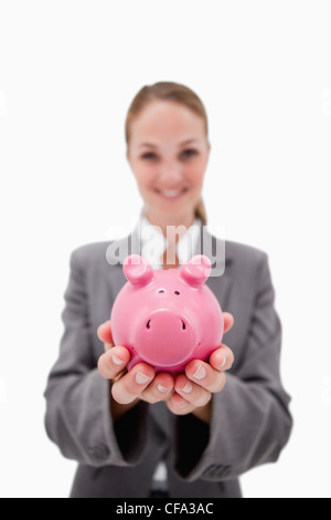 Piggy bank being offered by smiling bank employee against a white ...