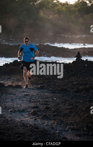 Man running on rocky beach Stock Photo - Alamy