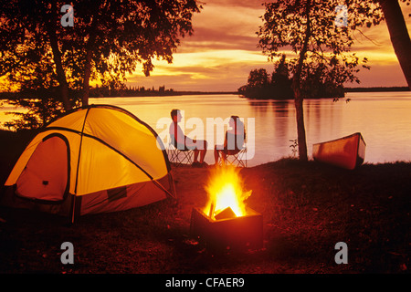 Couple relaxing at Otter Falls campground, Whiteshell Provincial Park ...