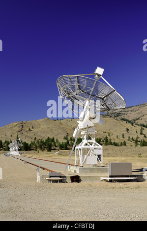 Three large satellite communication dish receivers against a clear sky ...