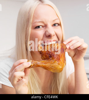 blond woman eating fried chicken in restaurant Stock Photo - Alamy