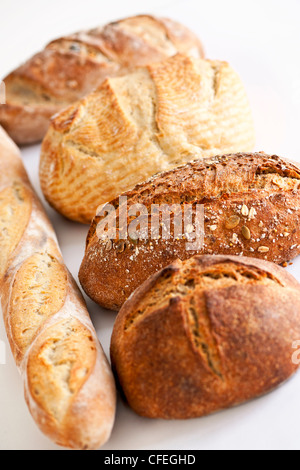 Freshly baked homemade wheat loaves on wooden background. Close-up ...