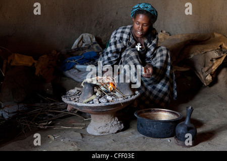 Ethiopian traditional Coffee ceremony women in traditional dress preparing bunna coffee in Addis ...