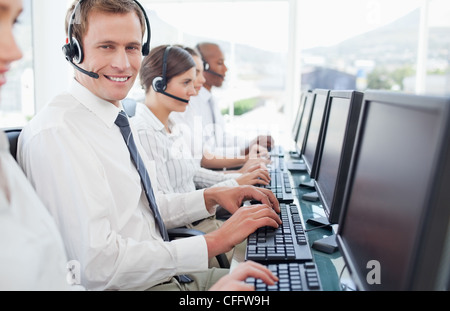 smiling call center employee sitting at his Desk Stock Photo - Alamy