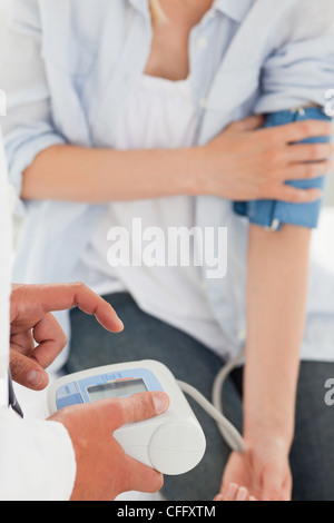 female doctor measuring patient blood pressure with medical device ...