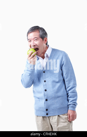 An elderly man biting an apple Stock Photo - Alamy