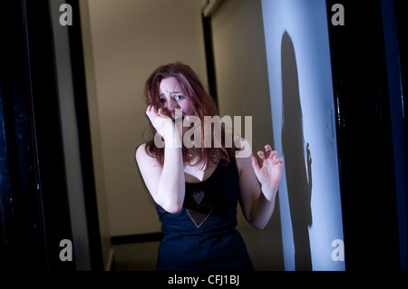 Scared young woman running away looking over shoulder Stock Photo ...