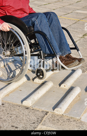 Closeup of handicapped woman practicing wheelchair riding over obstacle ...