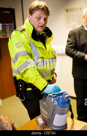 a uniformed police officer calibrating an SAFRAN morpho detection ...