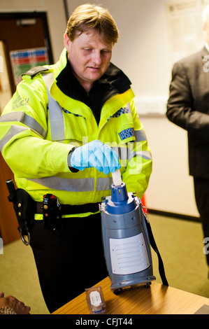 a uniformed police officer calibrating an SAFRAN morpho detection ...