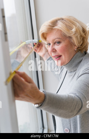 Woman measuring window with tape measure, tailoring service Stock Photo ...