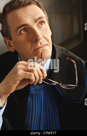 Attorney wearing classic gown thinking in court Stock Photo - Alamy