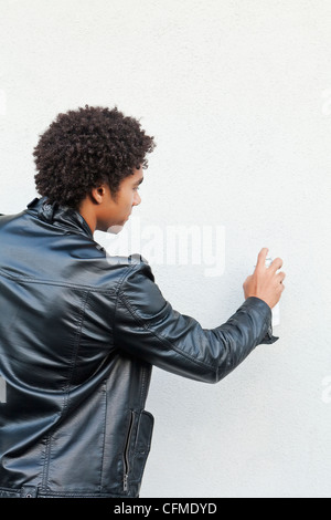 Man holding spray paint against white background, back view Stock Photo ...