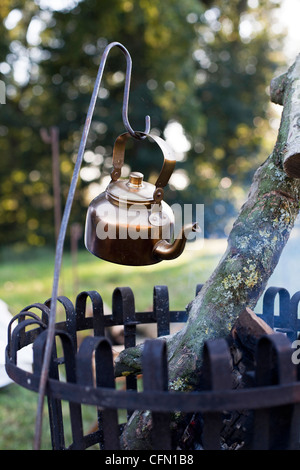 Copper kettle over an open fire in winter. Boiling kettle on firewood ...