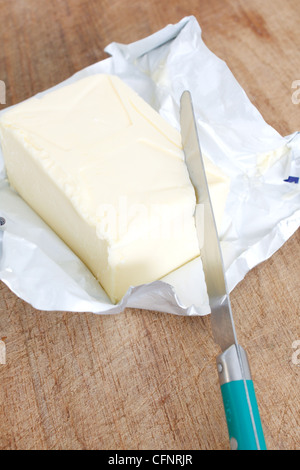 Block of butter with butter knife in a open pack. Buttering bread Stock ...