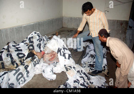 Karachi, Pakistan. SEP 12, 2012. People gather near dead bodies of ...