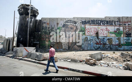 FILE - A man walks past a mural showing Bruce Lee and a dragon in San ...