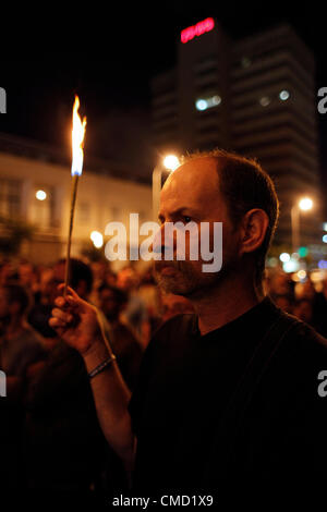 An Israeli demonstrator holds a lit torch during a demonstration in ...