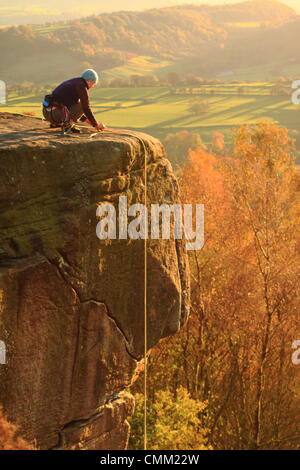 A rock climber tackles Froggatt Edge above the Derwent Valley on a fine ...