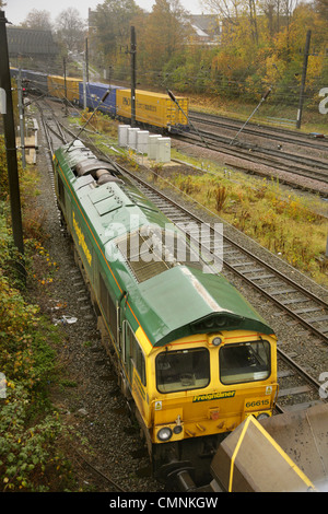 Class 66 diesel locomotive 66615 with train of empty coal wagons, and ...