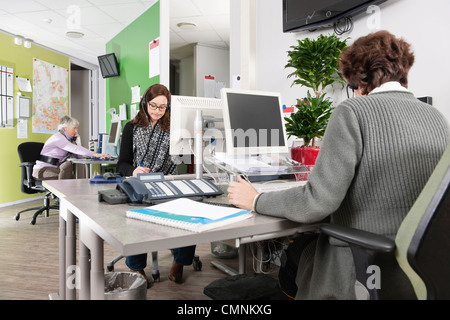 Nurse Making Phone Call At Nurses Station Stock Photo - Alamy