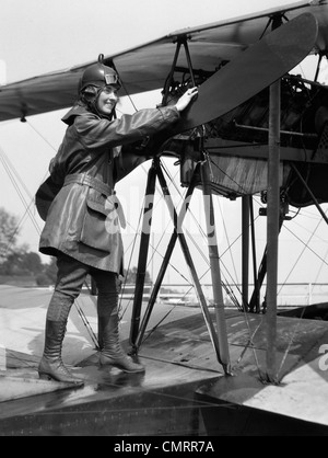 Woman pilot wearing vintage pilot helmet flight jacket and goggles ...
