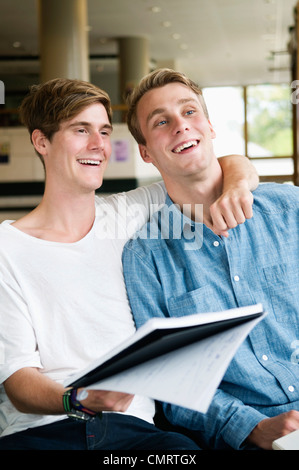 Two happy classmates student guys meeting in college library Stock ...