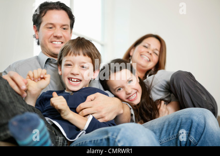 Mother romping with her laughing son at home in the living room Stock ...
