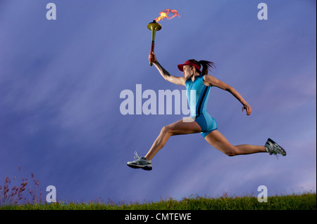 Caucasian athlete running with Olympic torch on park path Stock Photo ...