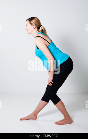 Pregnant woman performing a leg stretching exercise for the hamstring ...
