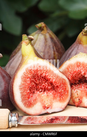 Figs in fig leaves on wooden table, top view Stock Photo - Alamy