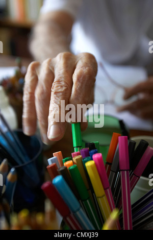 Elderly hand with wrinkled skin reaching out in a grabbing gesture ...
