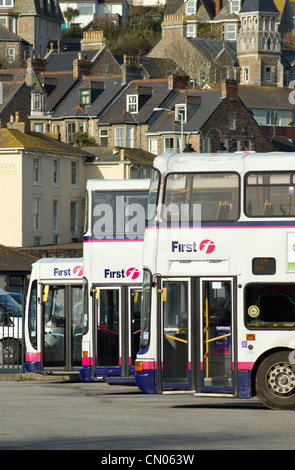 A First Group bus driver in a high visibility vest with two First Group ...