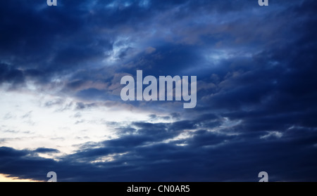 Heavy dark storm clouds covering the sky with patches of blue light ...