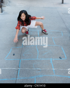 Young girl playing hopscotch at a city playground Stock Photo - Alamy
