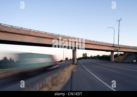 Highway overpass motion blur effect with modern city skyline background ...