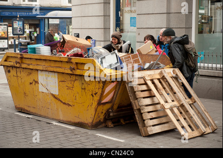 Skip raiding: People scavenging in a skip in the street for items ...