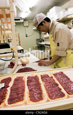 A butcher prepares slices Wagyu beef for sale at a branch of Uny ...