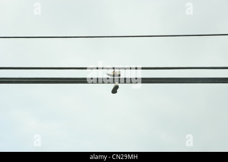 Shoes on a telephone line Stock Photo - Alamy