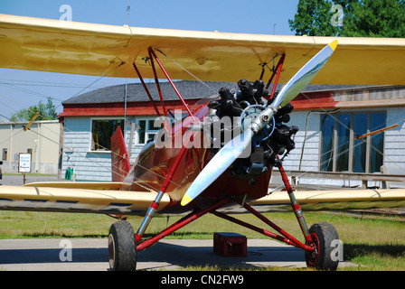 Biplane at an old fashioned airfield. This maroon fabric covered ...