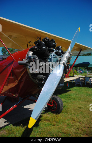 Biplane at an old fashioned airfield. This maroon fabric covered ...