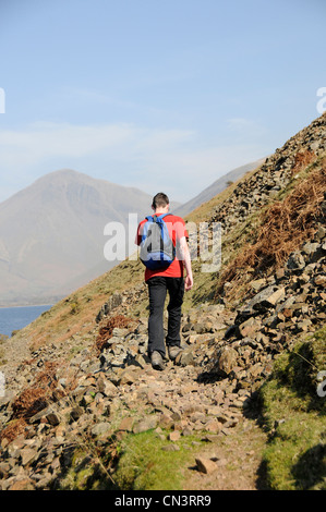 Young man walking on the screes at wastwater in the lake district uk ...
