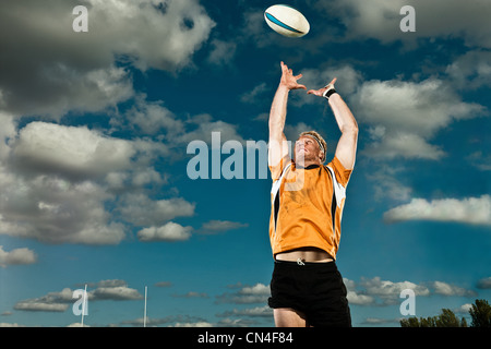 Caucasian rugby player with ball jumping over computer language, grid ...