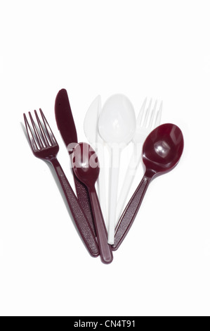 A vertical shot of plastic forks and a knife on a yellow background ...