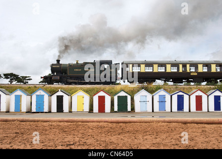 Steam train passing above beach huts on its way to Kingswear on the ...
