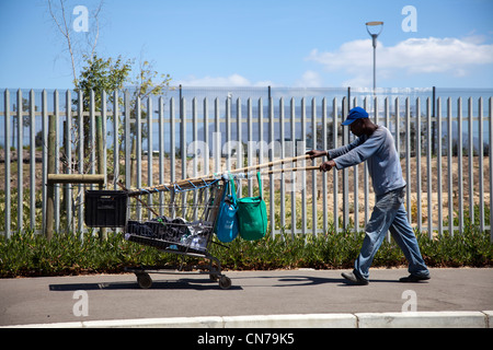 Homeless man pushing trolley with his belongings through lower Stock ...