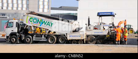 Tipper lorry and Tarmac laying machine with road roller and workmen ...
