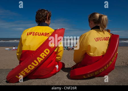 Two lifeguards sitting on duty outside their hut on the beach at ...