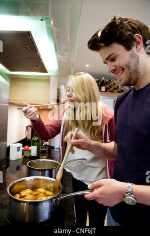 Young man and woman cooking food in kitchen together, happy couple ...
